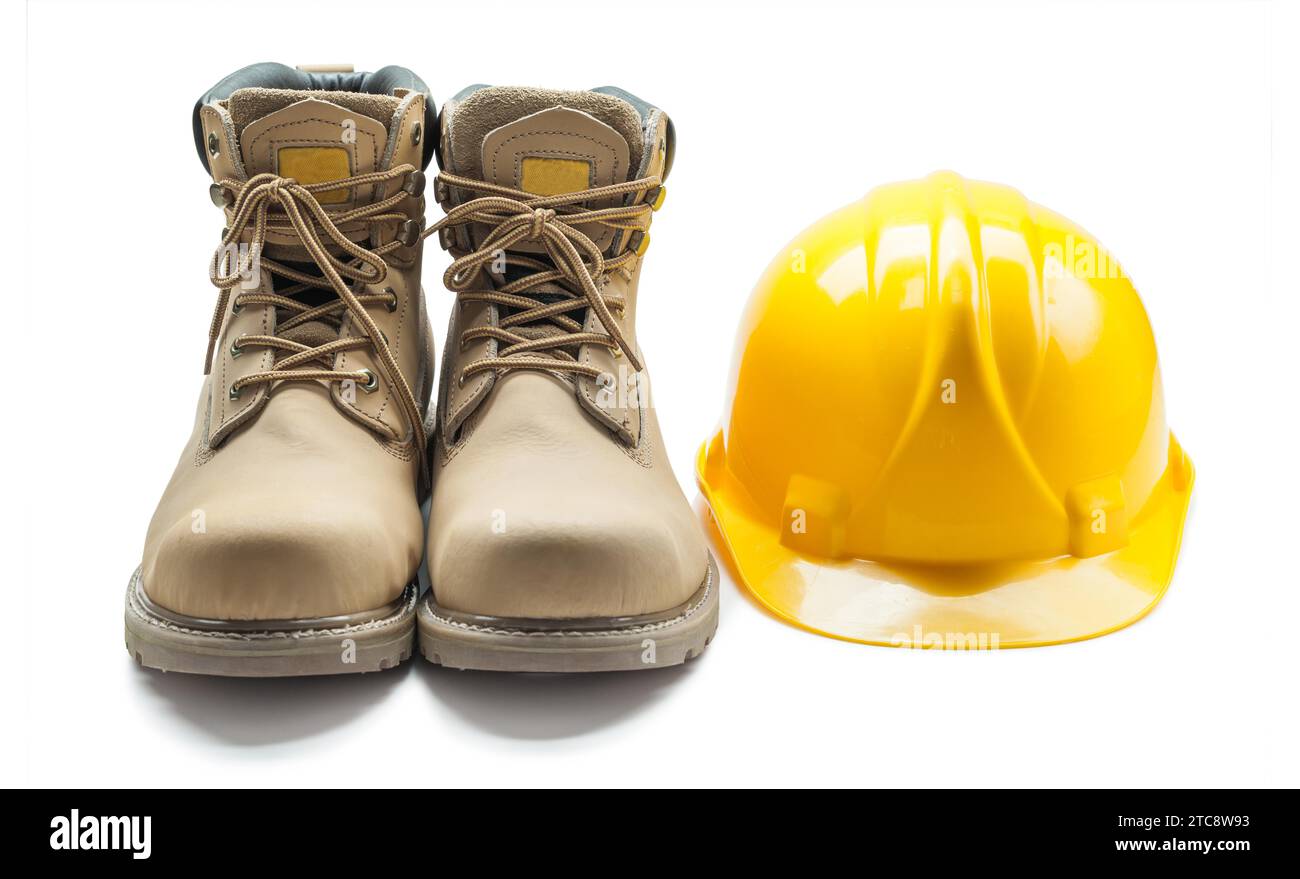 Construction tools leather work boots and yellow helmet against a white ...