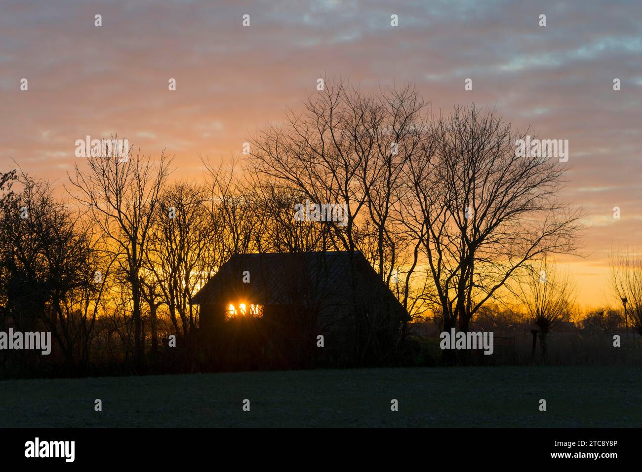 Sunset, sky burning, evening sun shining through a window of a house ...