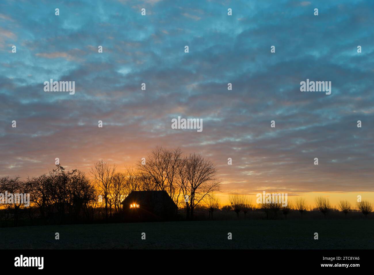 Sunset, sky burning, evening sun shining through a window of a house ...