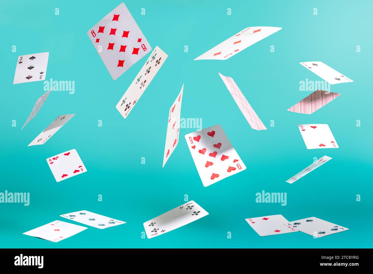 Many flying playing cards on a turquoise background Stock Photo - Alamy
