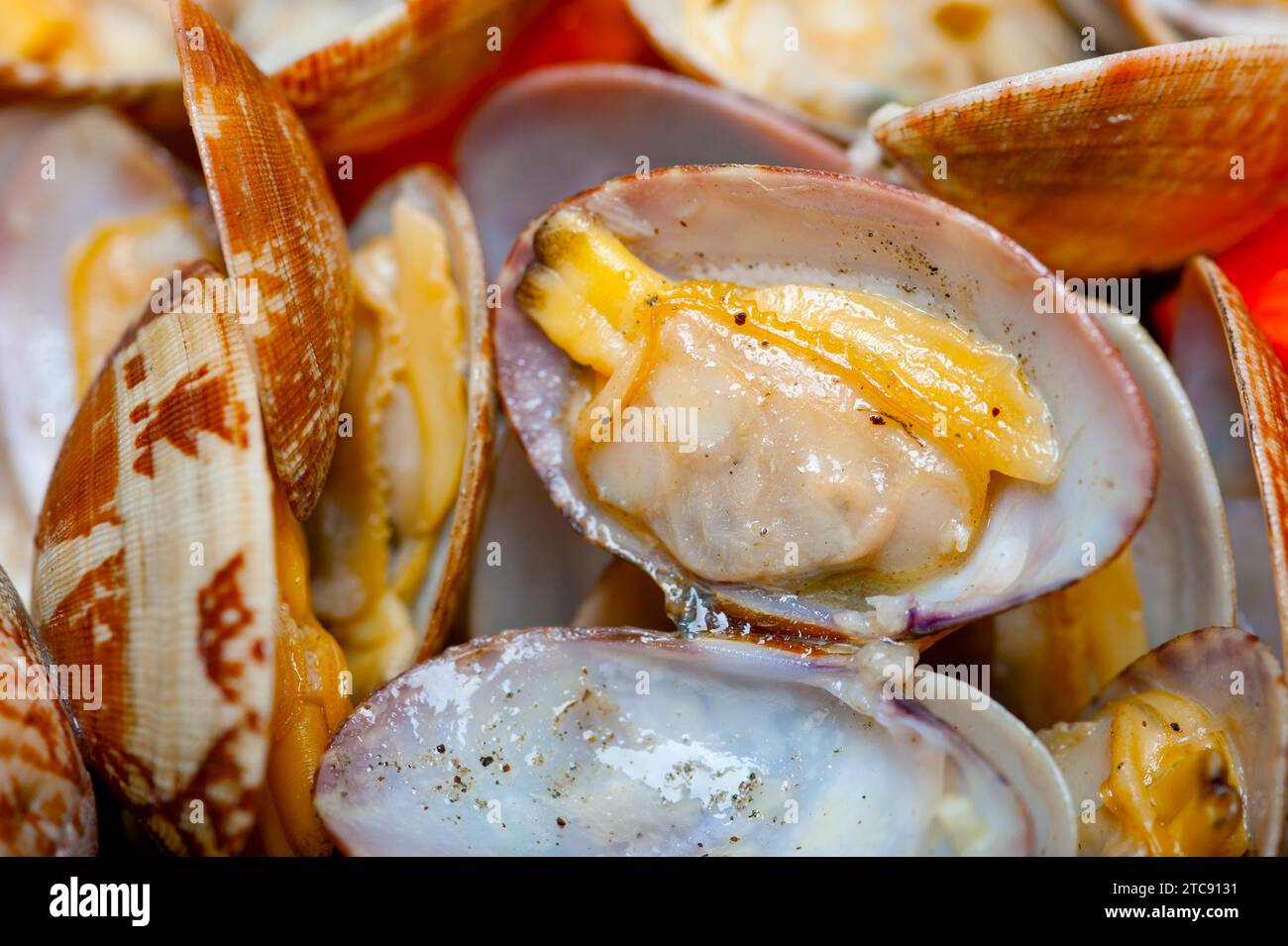 Fresh clams stewed on an iron skillet over wite rustic wood table Stock ...