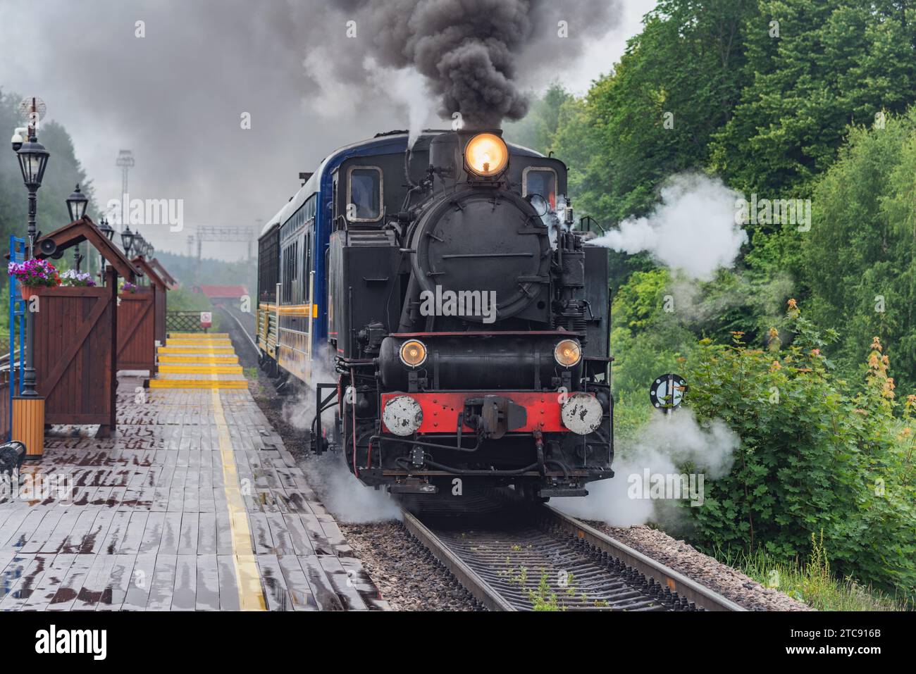 Retro steam train approaches to the platform Stock Photo - Alamy