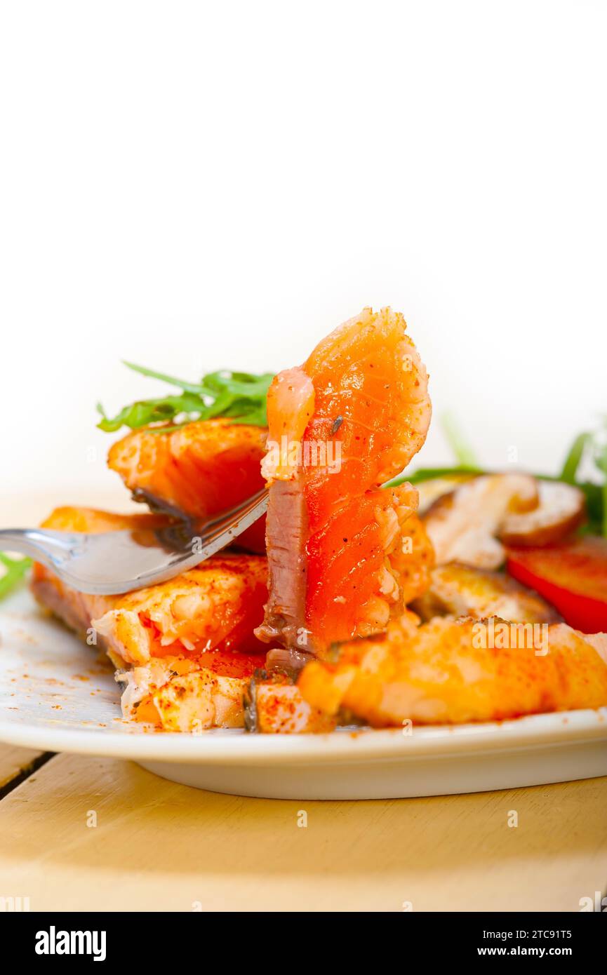 Grilled fresh samon filet with vegetables salad tomato arugula ...