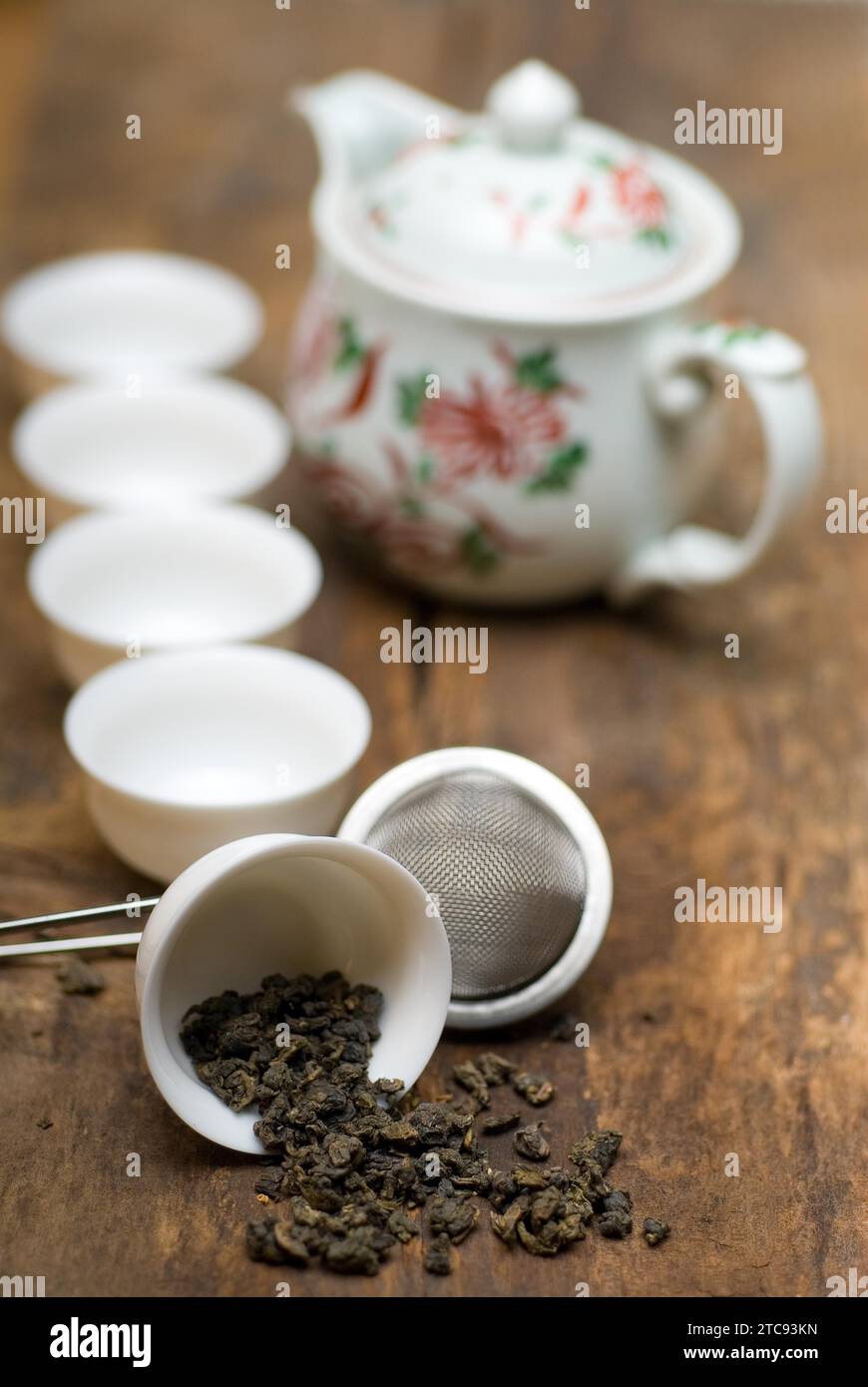 Dry green chinese tea set, with strainer closeup, cups and teapot on ...