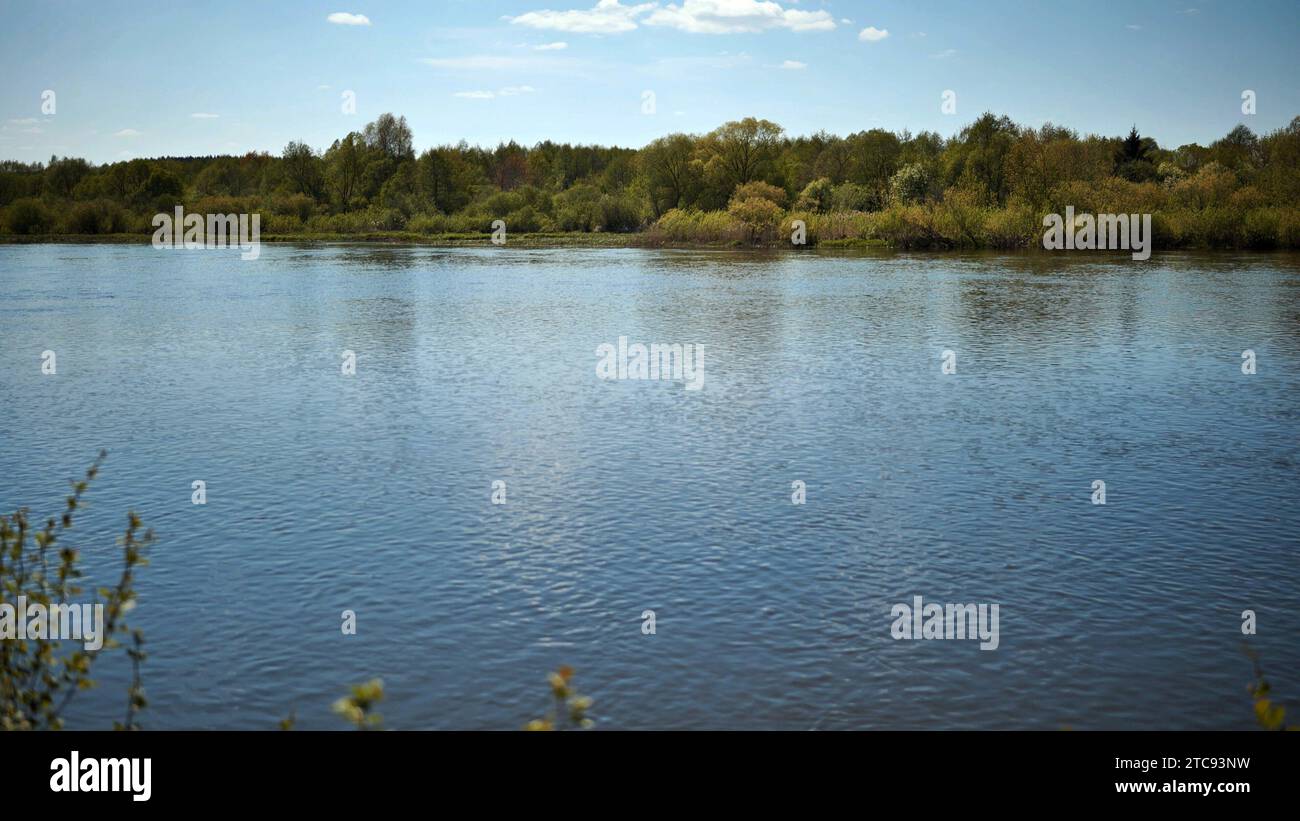 Reflection in the Neman River of cumulus clouds and the river bank ...