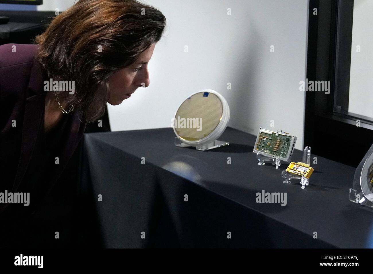 U.S. Commerce Secretary Gina Raimondo examines a six-inch wafer of ...
