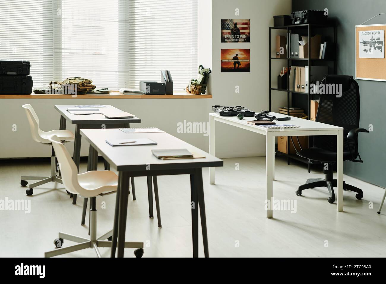 Two desks with chairs standing in front of workplace of military ...