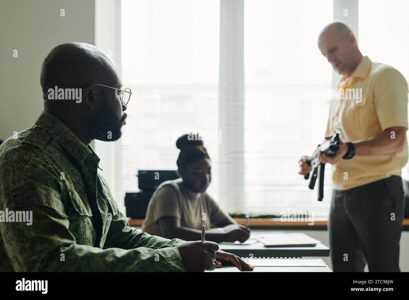 Young African American man in military uniform making notes while ...