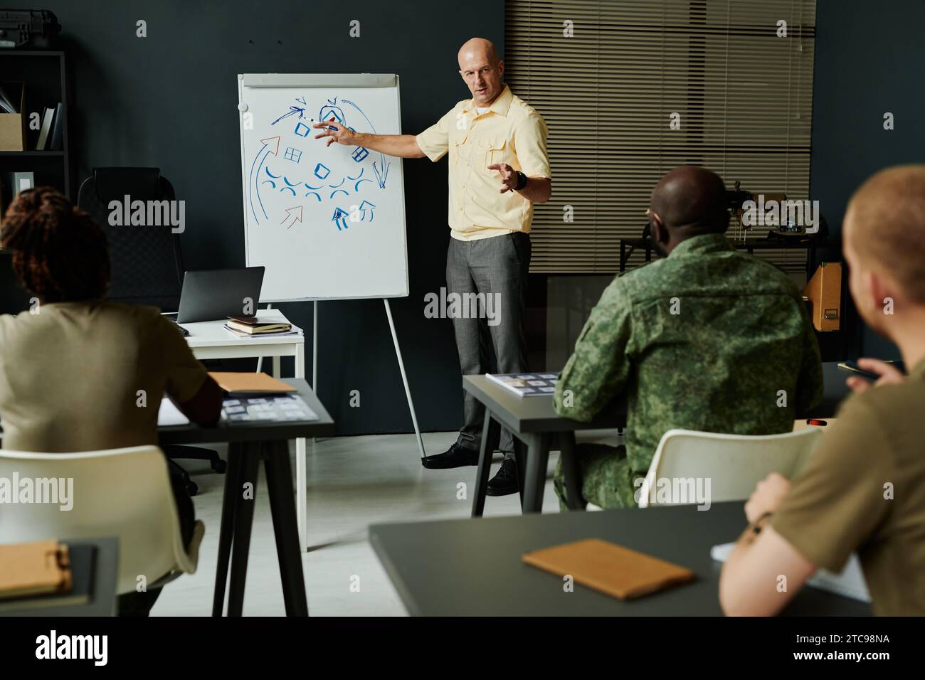 Confident mature teacher pointing at whiteboard with arrows and ...