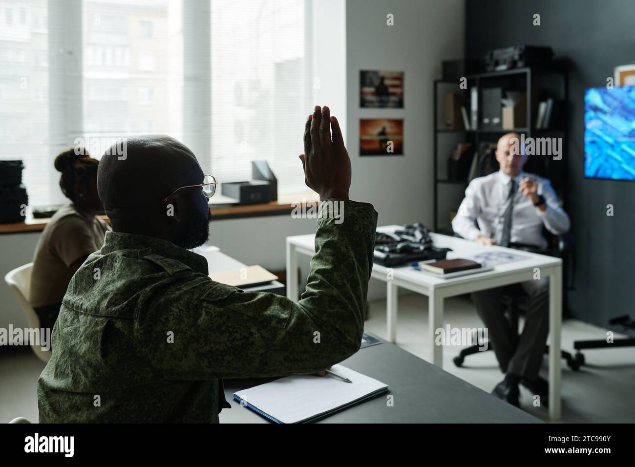 Focus on young African American male student raising hand to ask ...