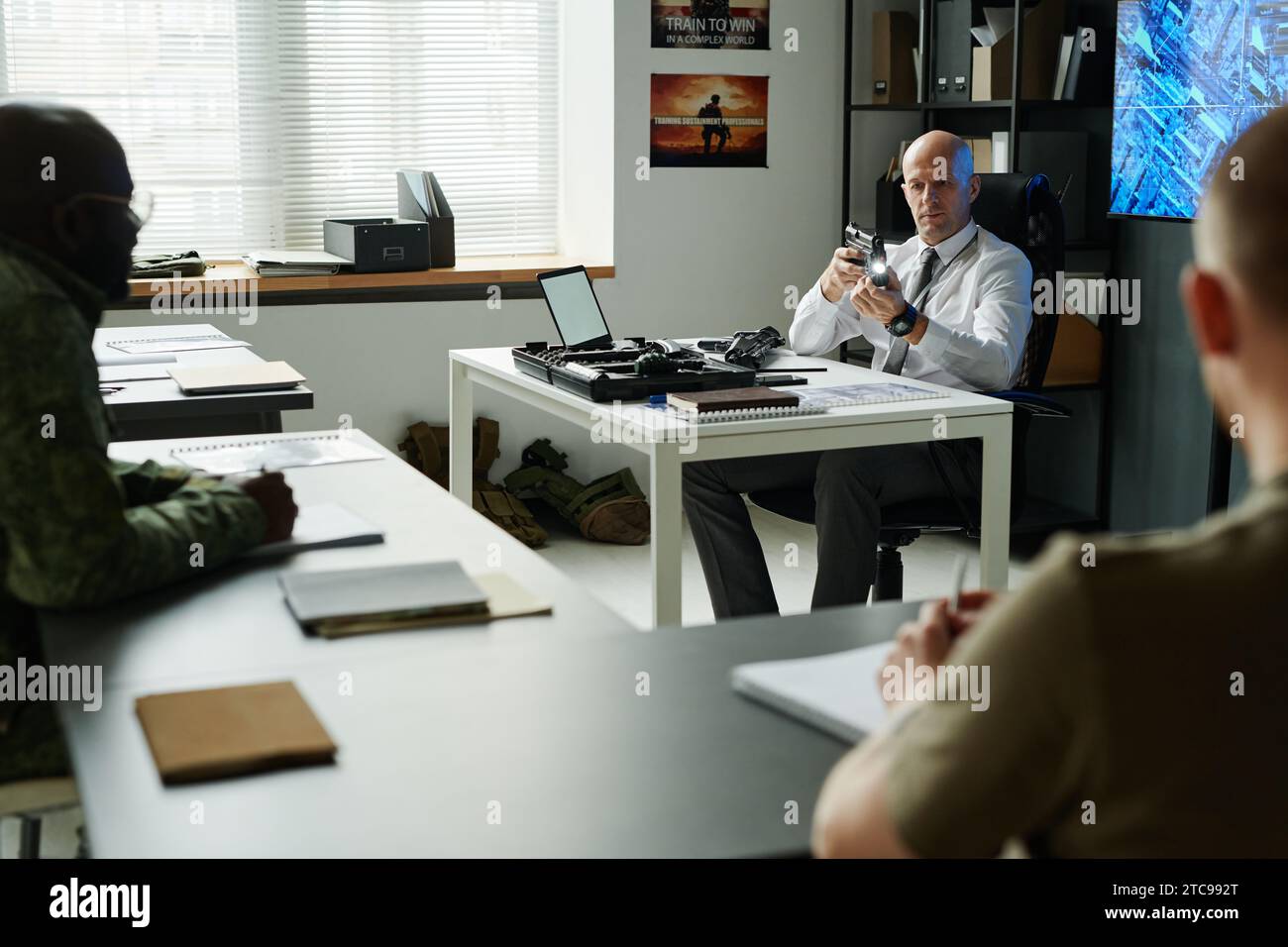 Mature male military training coach teaching students how to shoot ...
