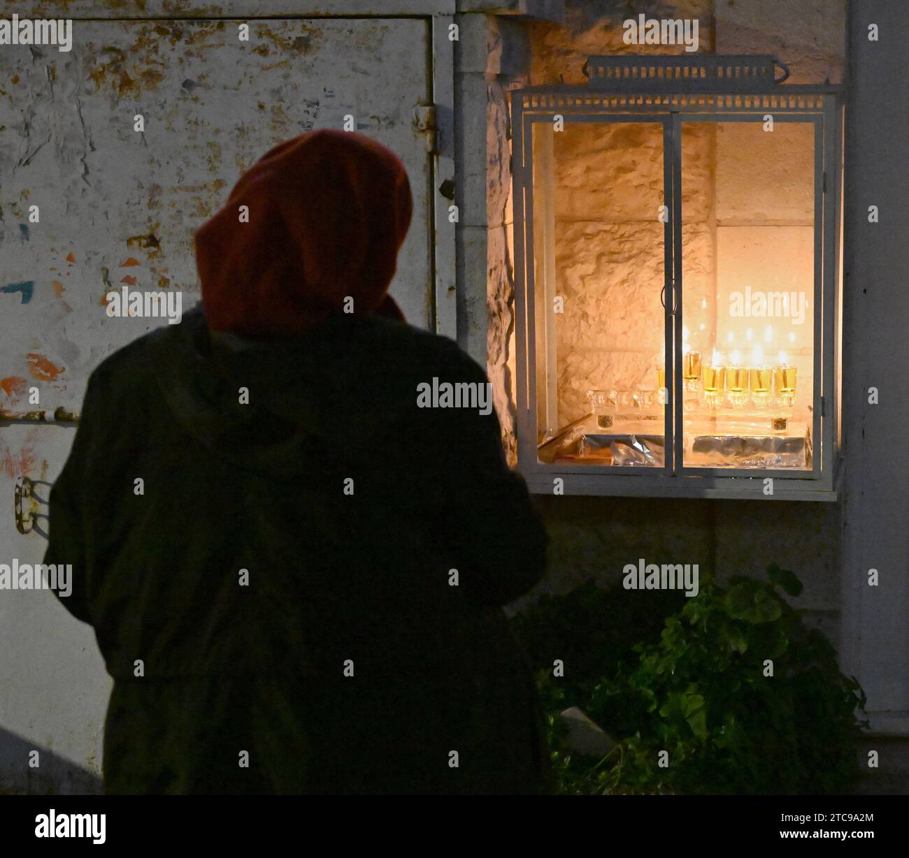 Jerusalem, Israel. 11th Dec, 2023. A woman prays in front of the lights ...