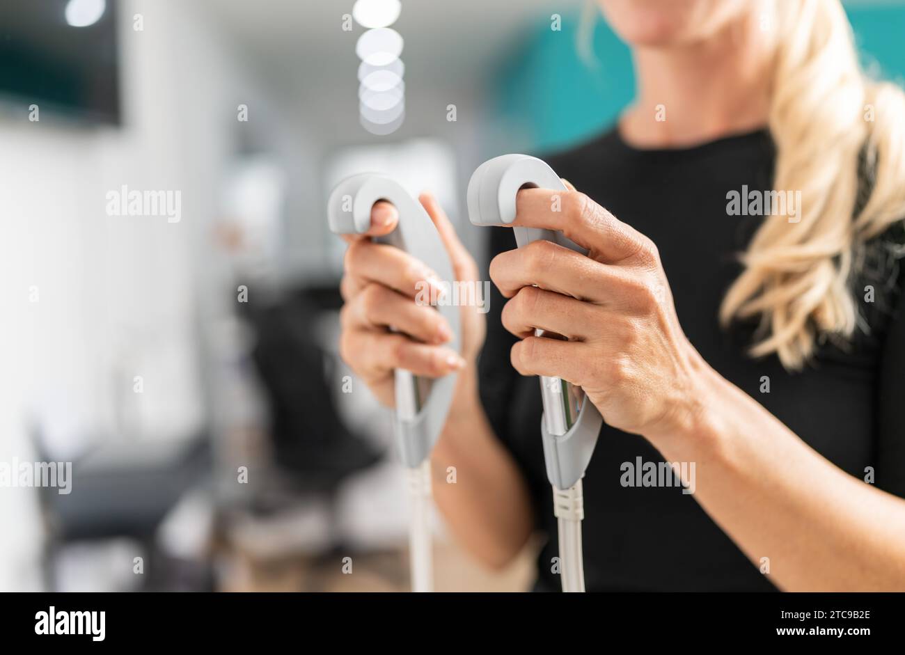 Close-up of a woman's hands holding the handles of a body composition ...