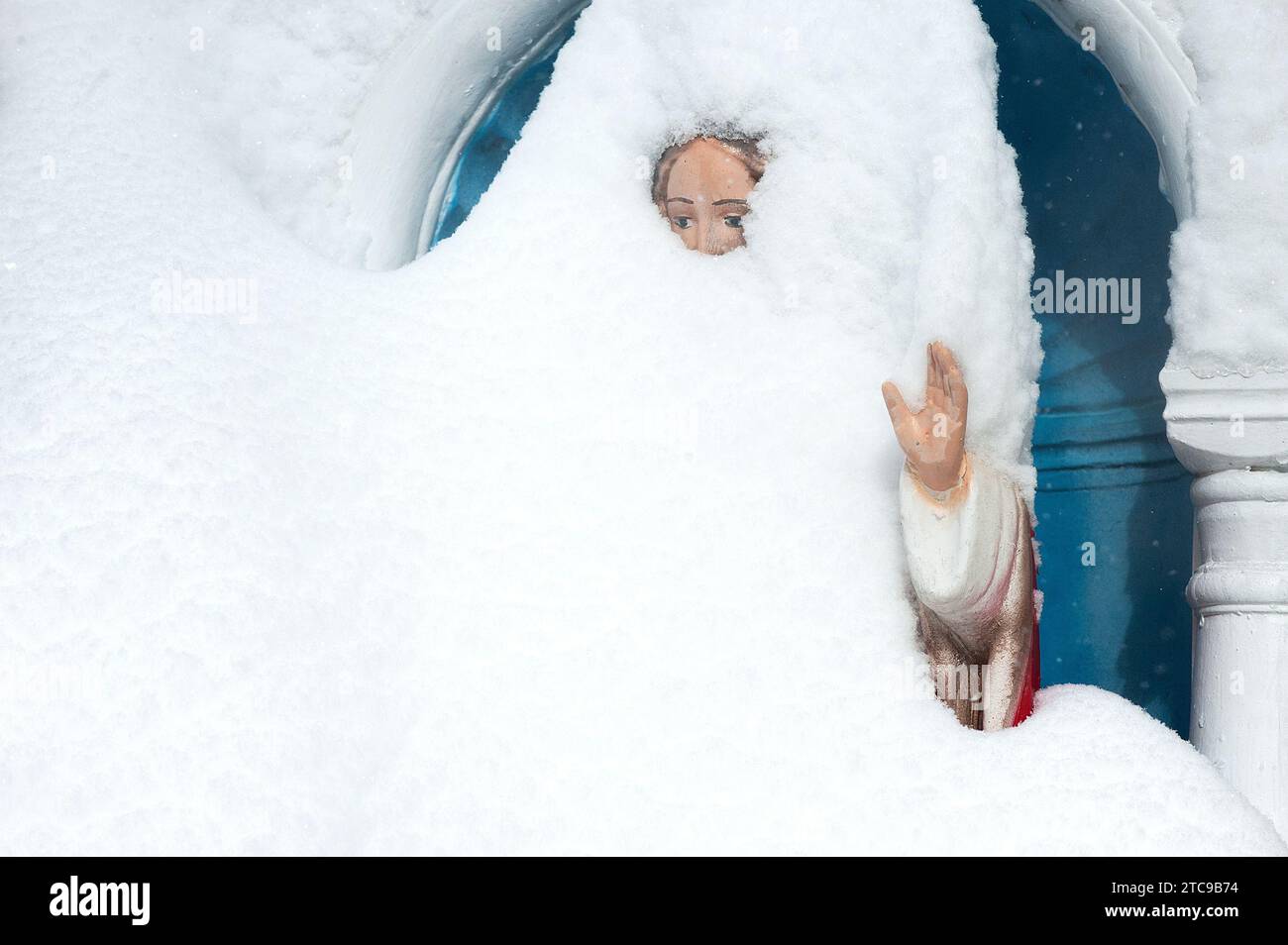 Snow covered religious statue of Jesus Stock Photo - Alamy