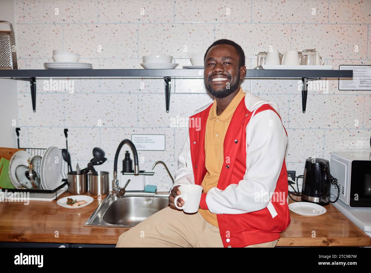 Waist up portrait of smiling Black man wearing varsity jacket smiling ...
