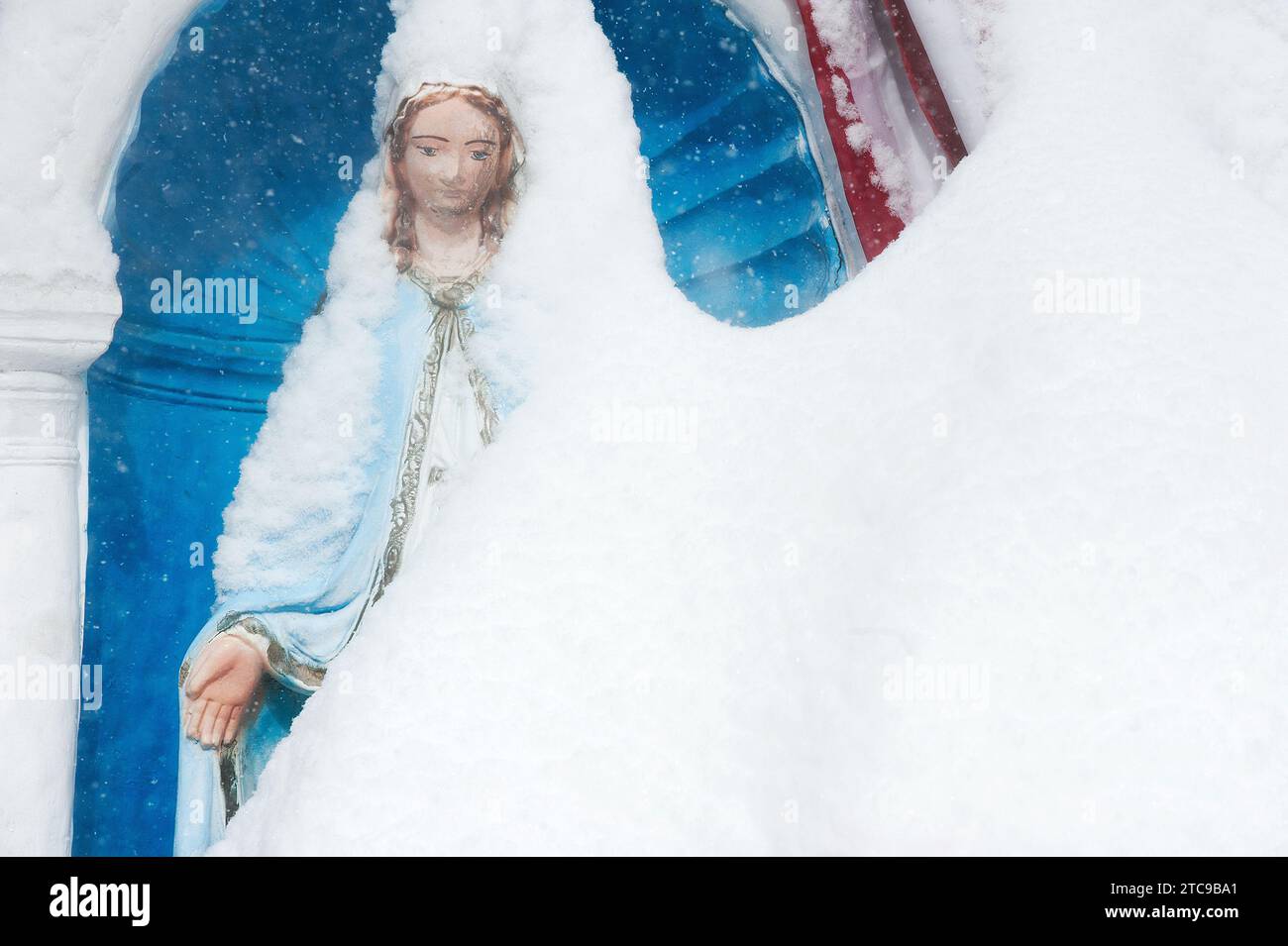Snow covered religious statue of the virgin Mary Stock Photo - Alamy