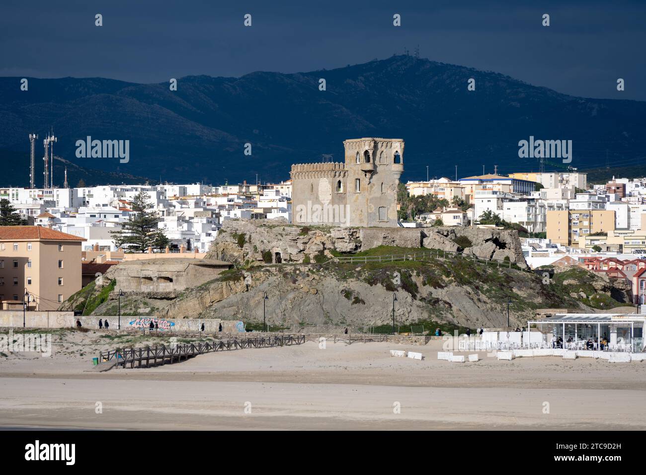 Historic castle overlooking a coastal town under cloudy skies Stock ...