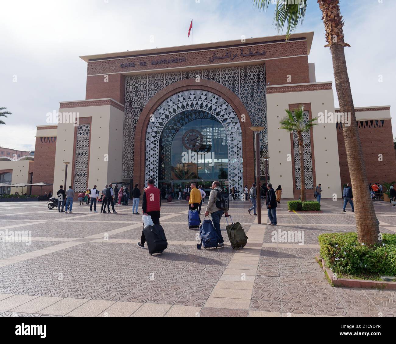 Travellers outside the modern glass fronted Train Station in the city of Marrakesh aka Marrakech ...