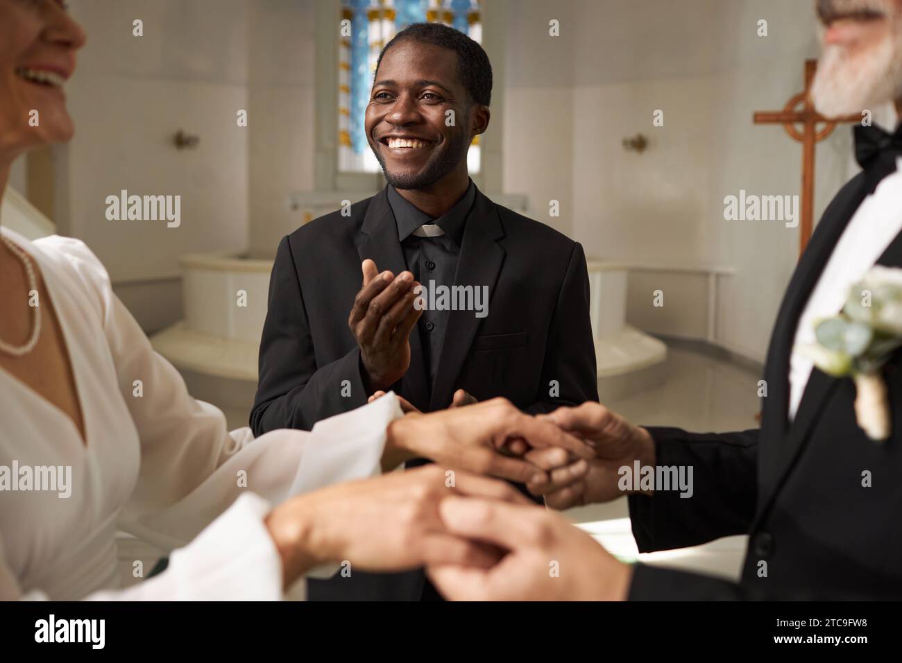 Waist up portrait of smiling Black man as priest officiating wedding in ...