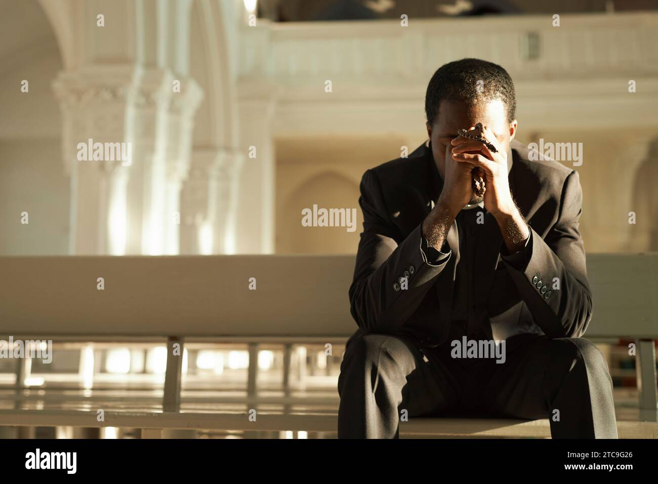 Young priest praying rosary in hi-res stock photography and images - Alamy