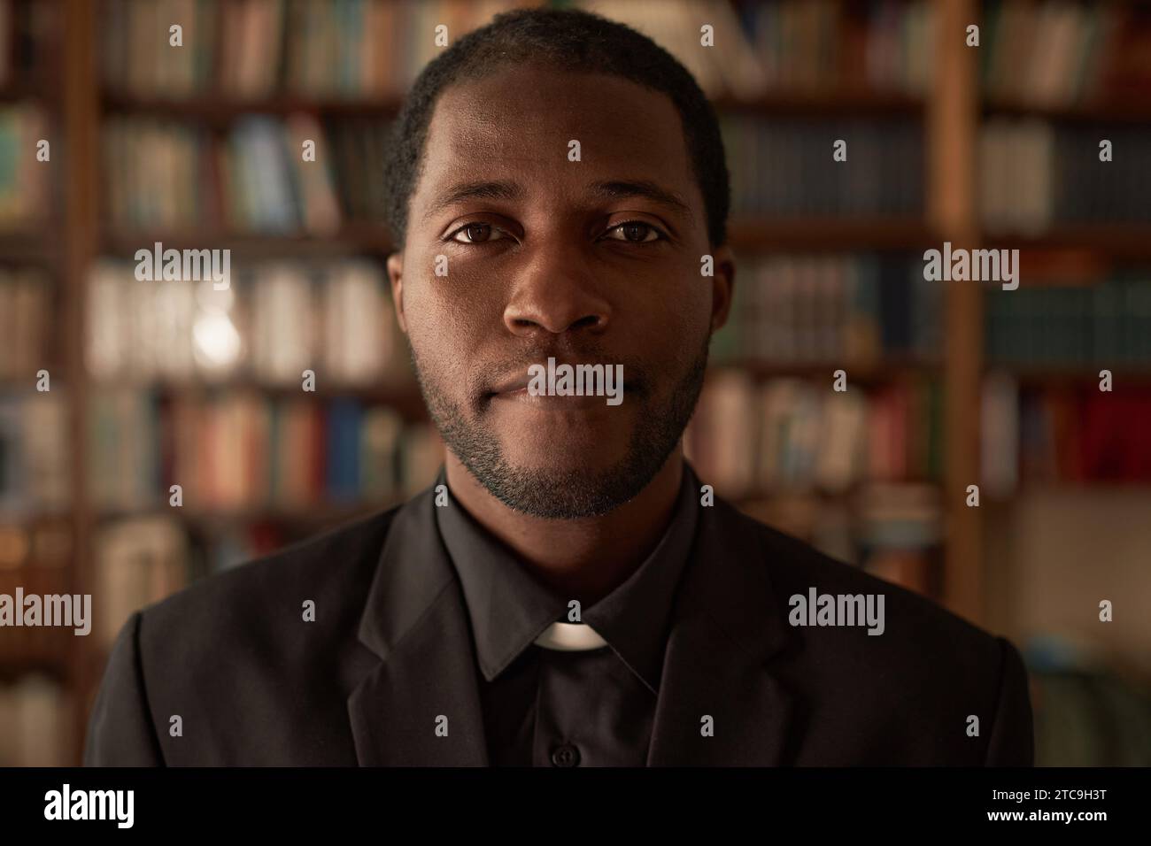 Closeup portrait of young African American priest looking at camera in ...
