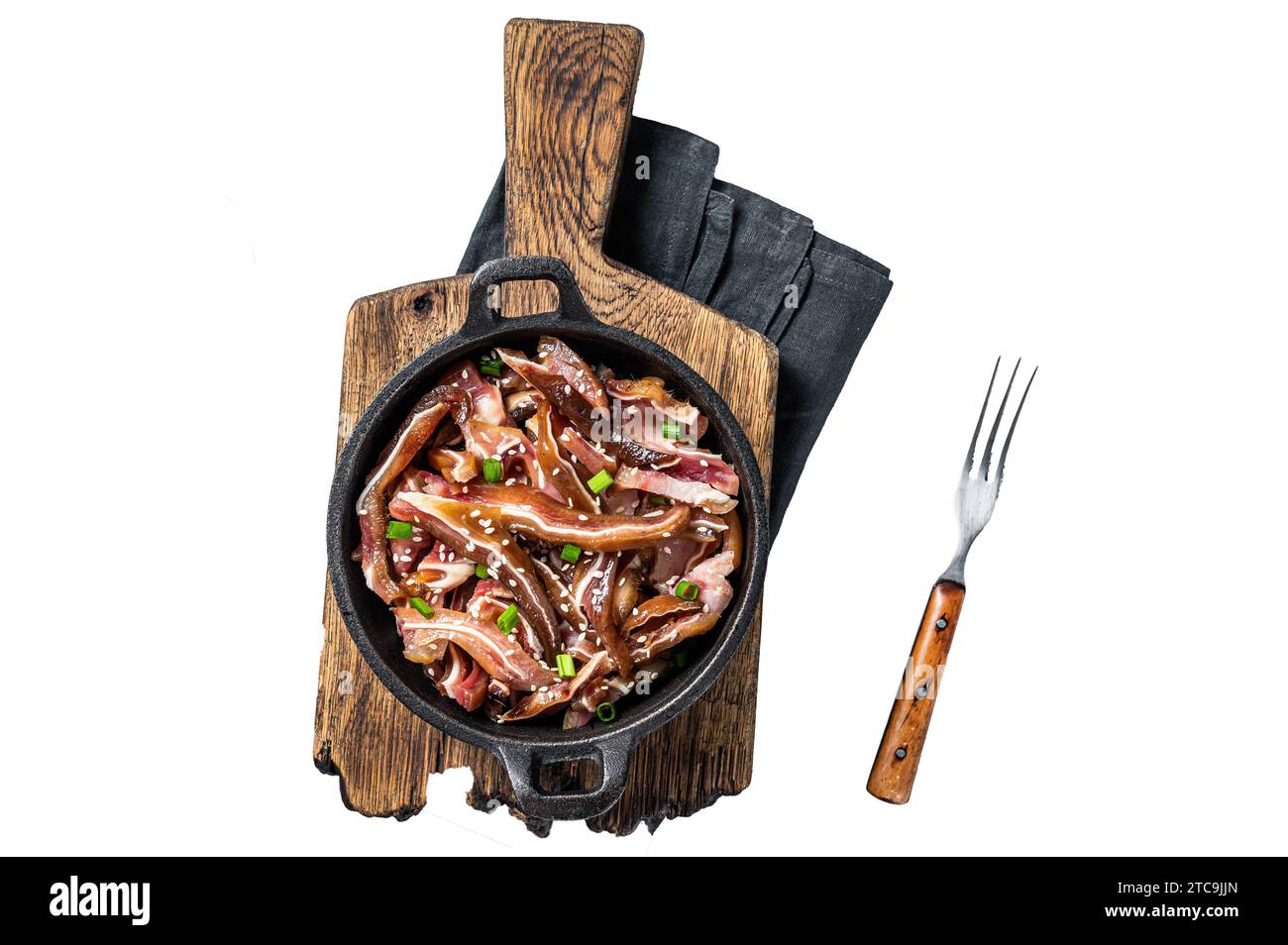 Fried spicy pork pig ears served in a frying pan. Isolated, white ...