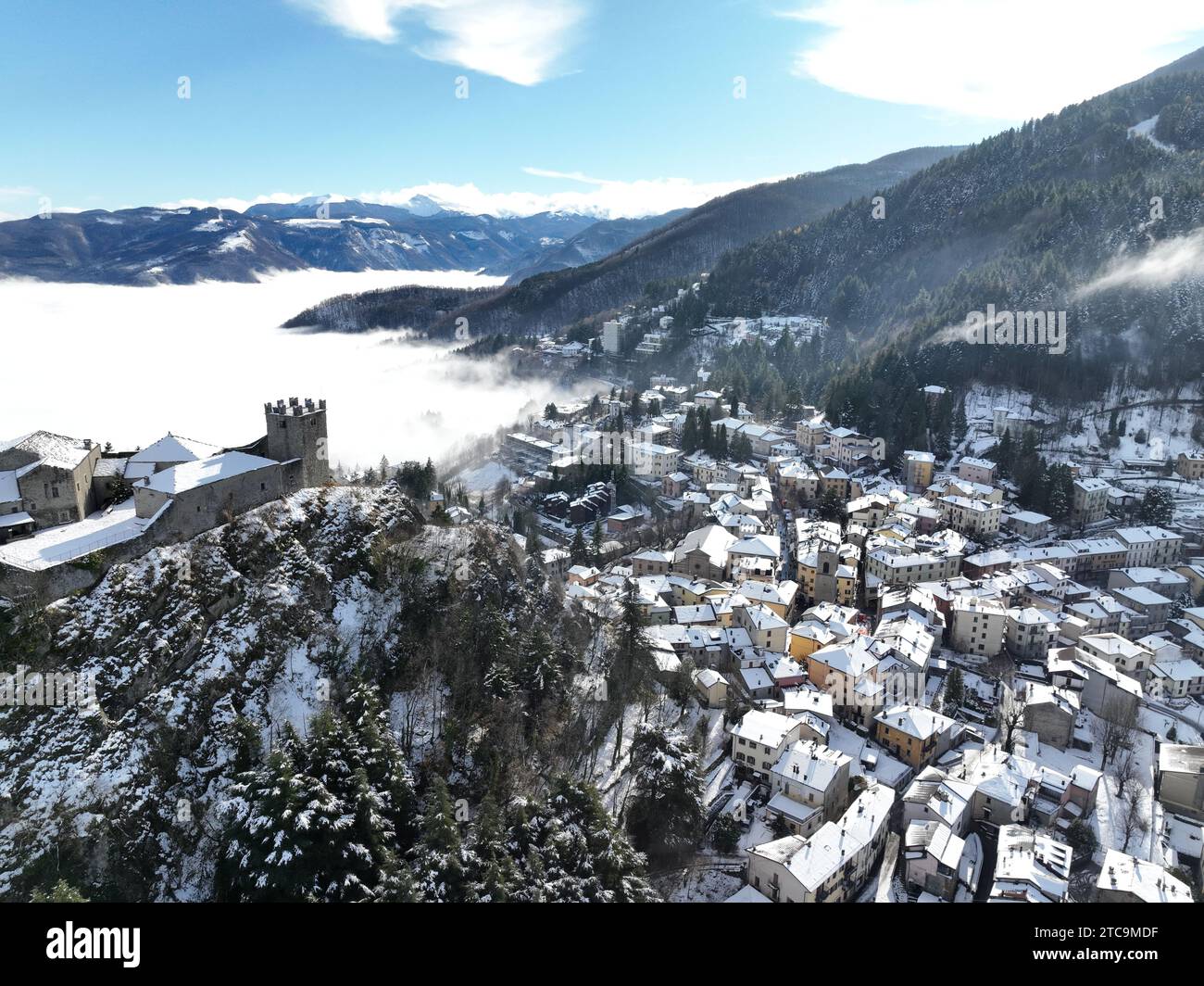 A picturesque view of a small town situated atop a snowy mountain peak ...