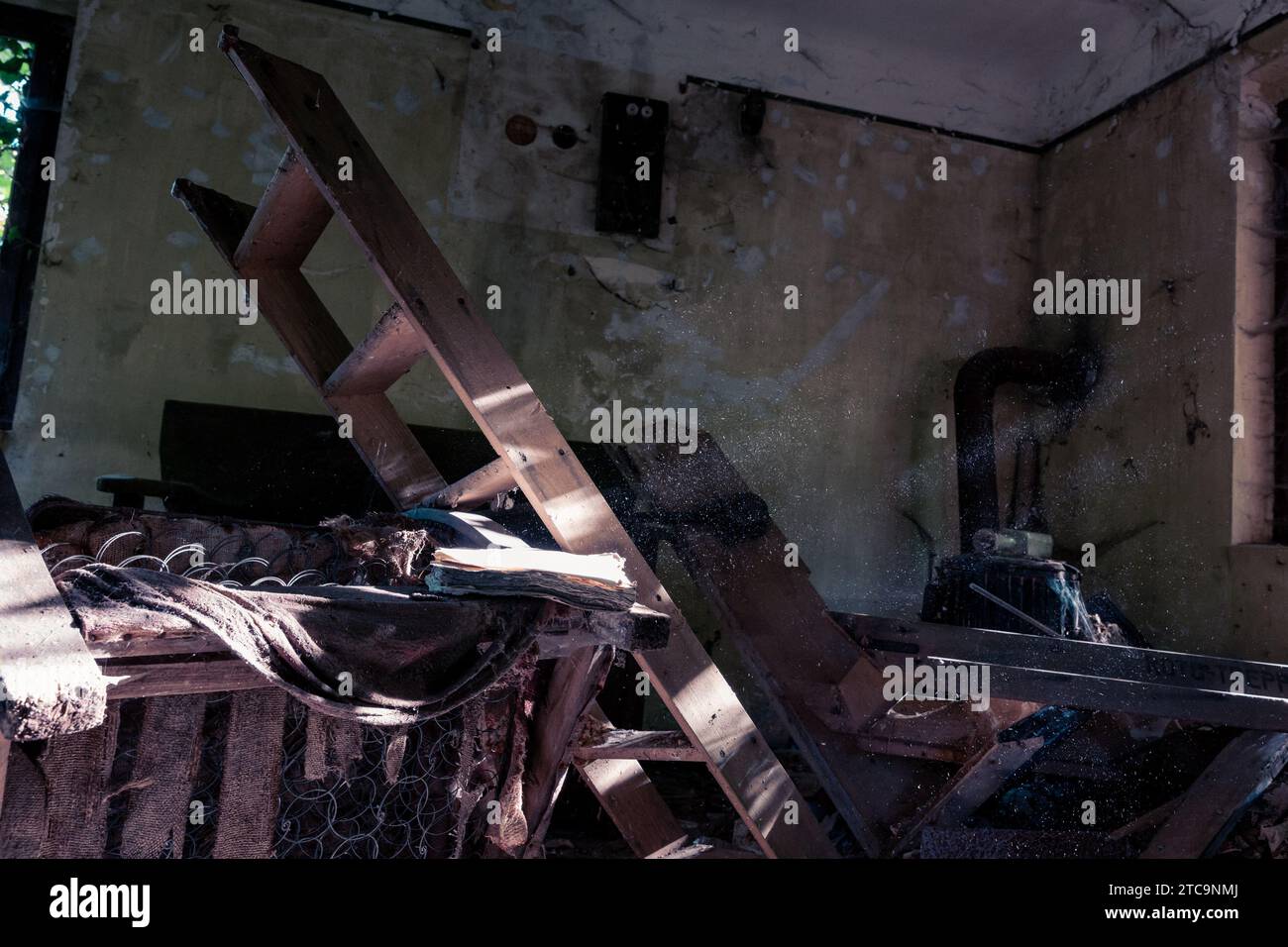 An interior shot of a damaged bedroom, featuring an unmade bed with ...