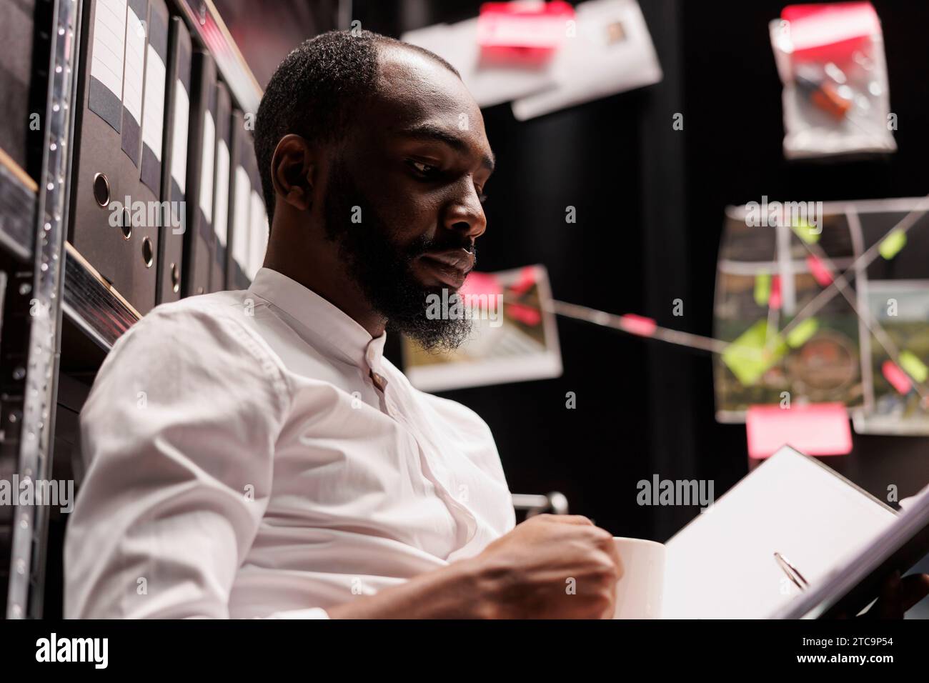 African american investigator reading police documentation, working ...