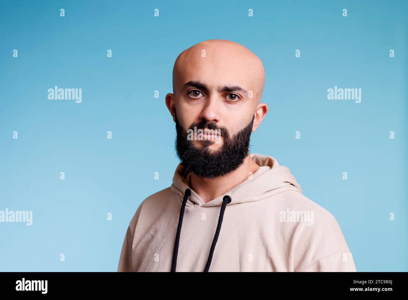 Young bald arab man with relaxed facial expression studio portrait ...