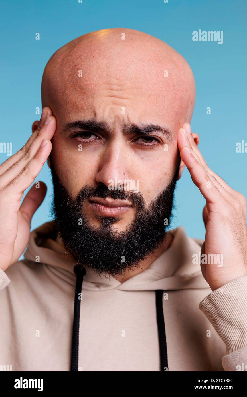 Young bald man and rubbing head hi-res stock photography and images - Alamy