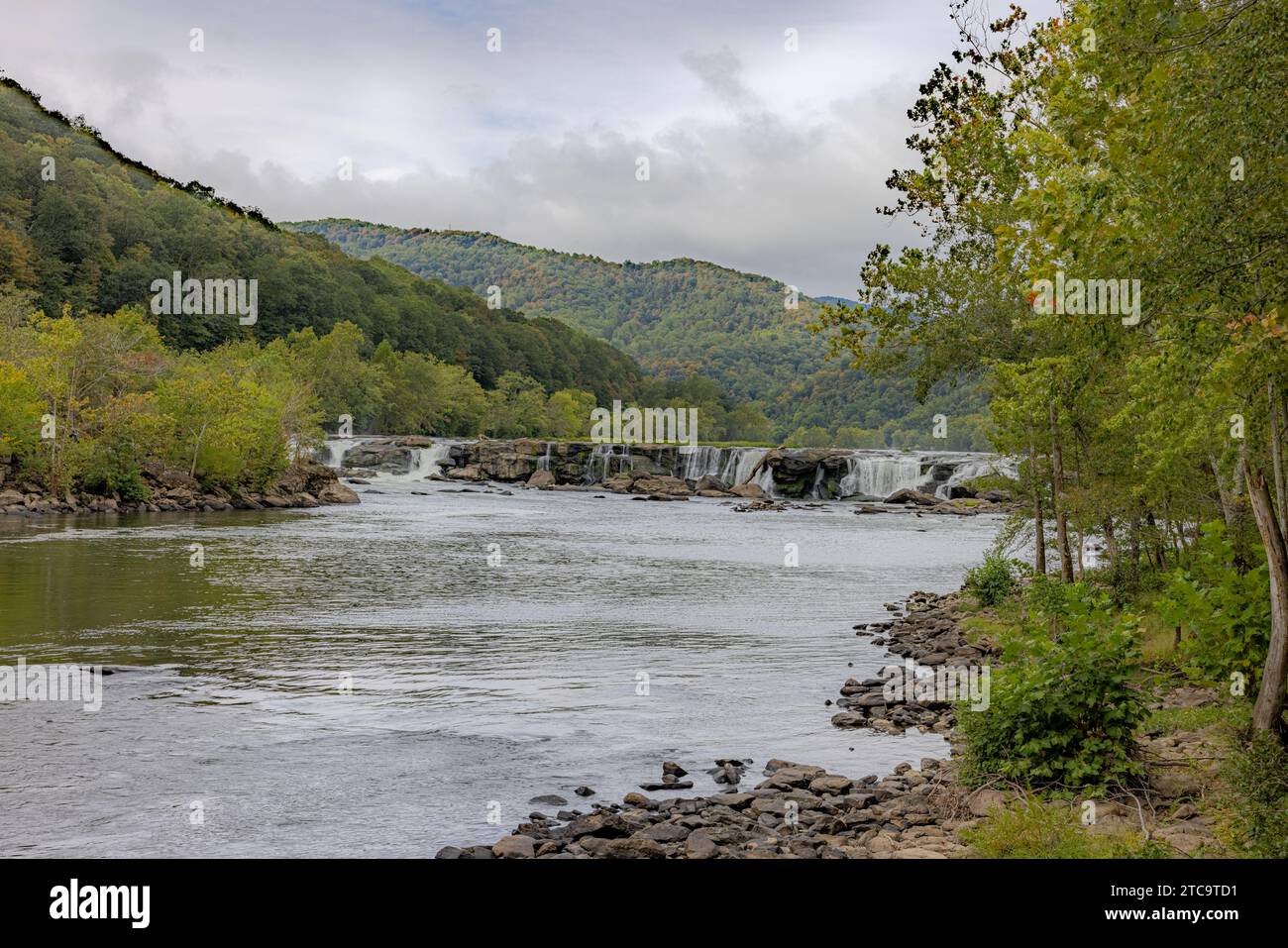 A picturesque landscape featuring a winding river snaking alongside a ...