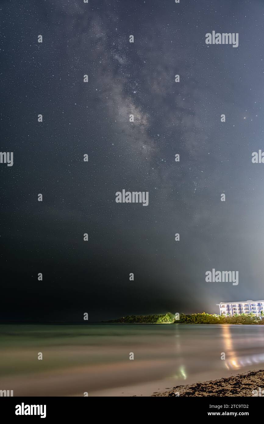 A luminous night sky dotted with stars is illuminated over a tranquil ...