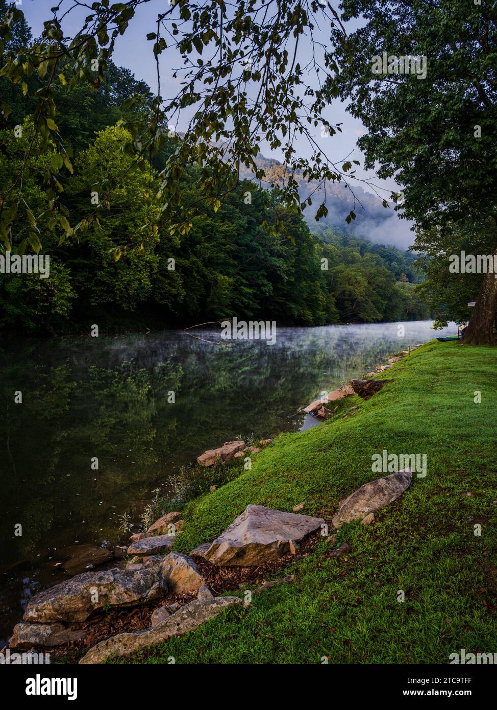 A tranquil landscape featuring a serene river winding through a lush ...