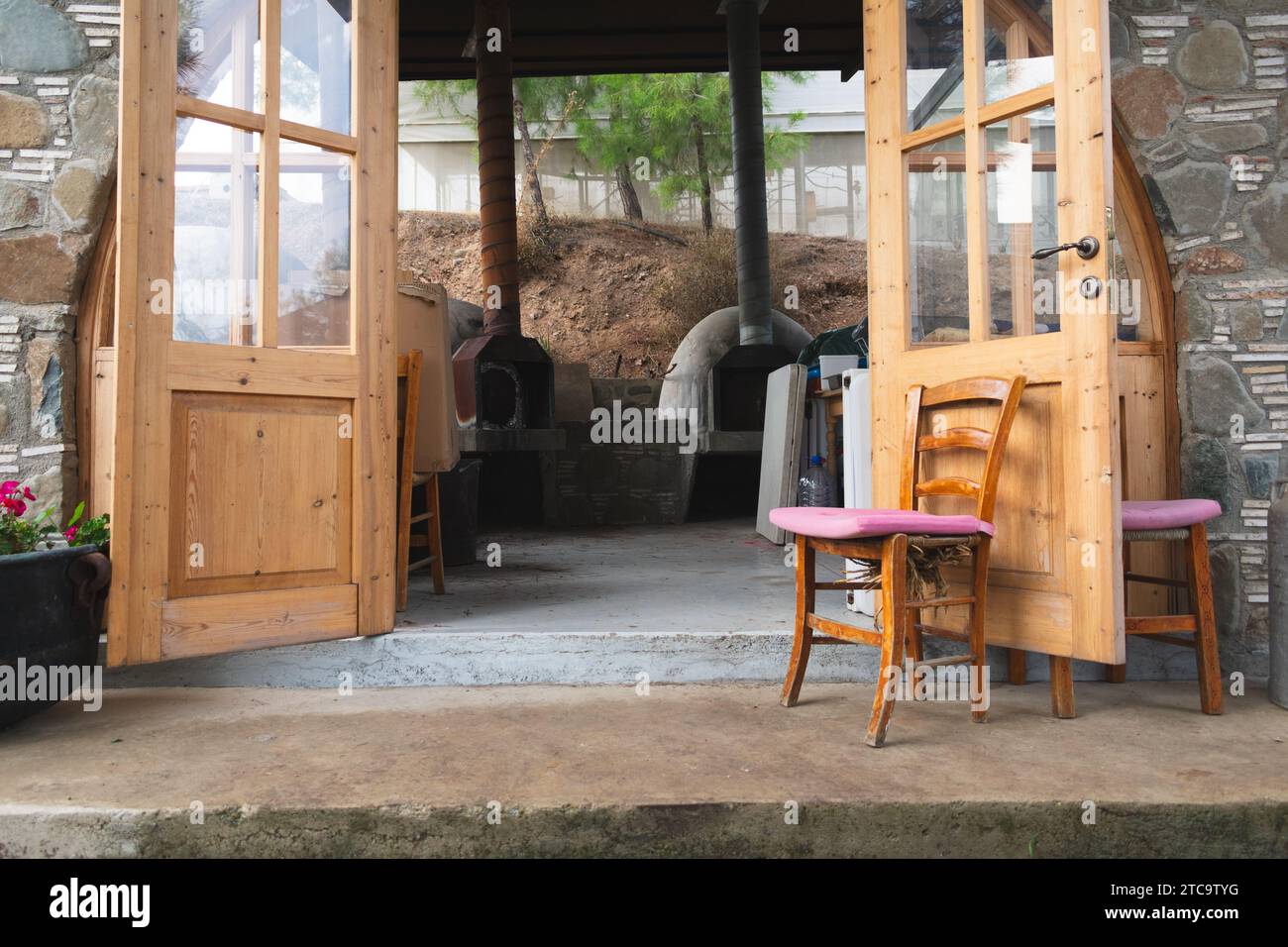 An open white wooden door with a matching chair positioned in front of ...