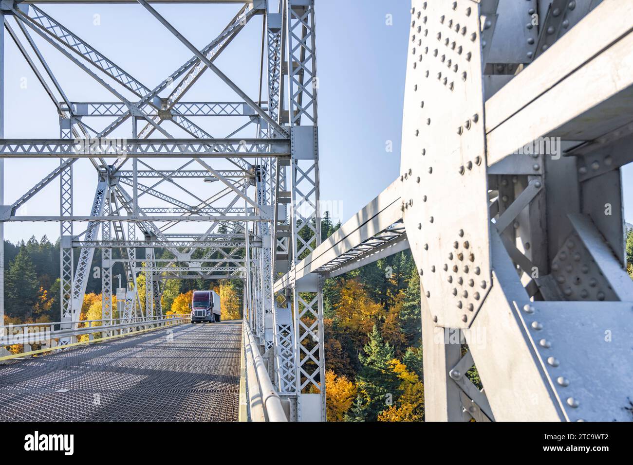 Bonnet burgundy big rig industrial semi truck transporting cargo in dry ...