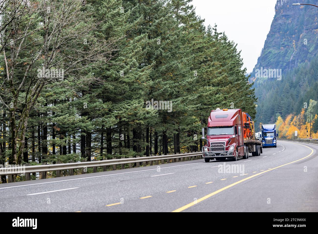 Convoy of the industrial standard big rig semi trucks with loaded semi ...