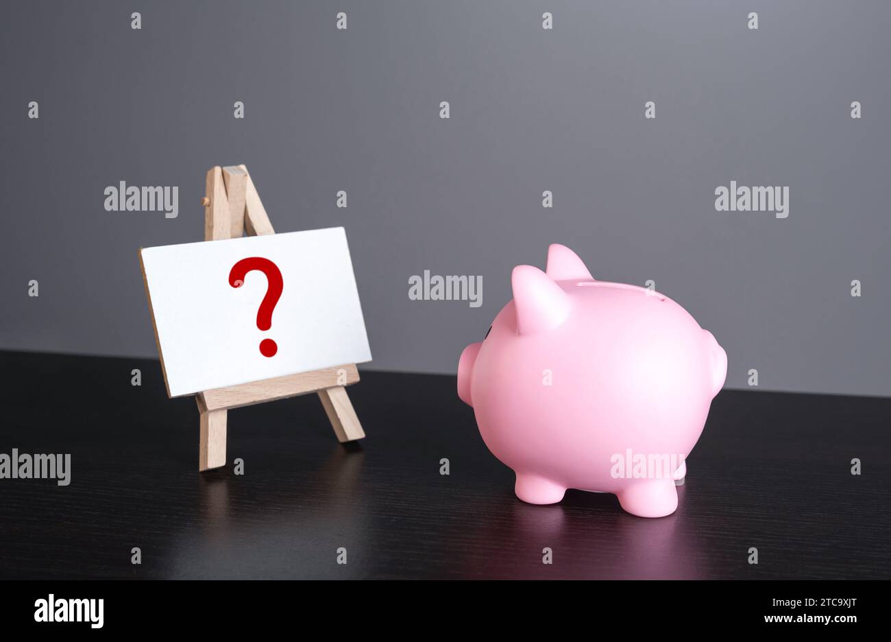 Piggy bank looking at the question mark on the stand. Financial ...