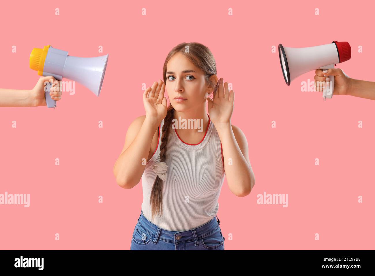Teenage girl trying to hear something and hands with megaphones on pink ...