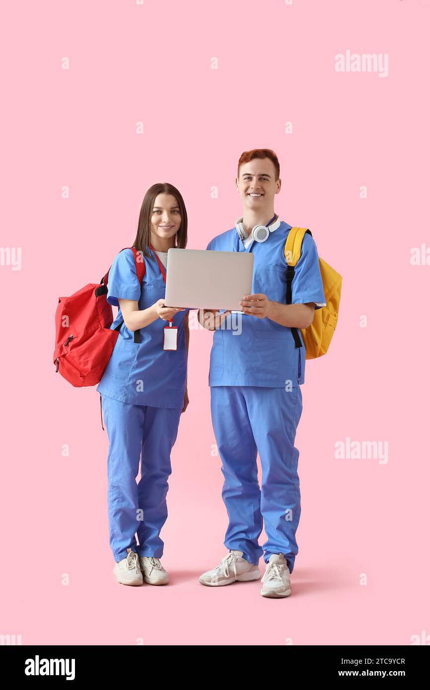 Medical students with laptop on pink background Stock Photo - Alamy