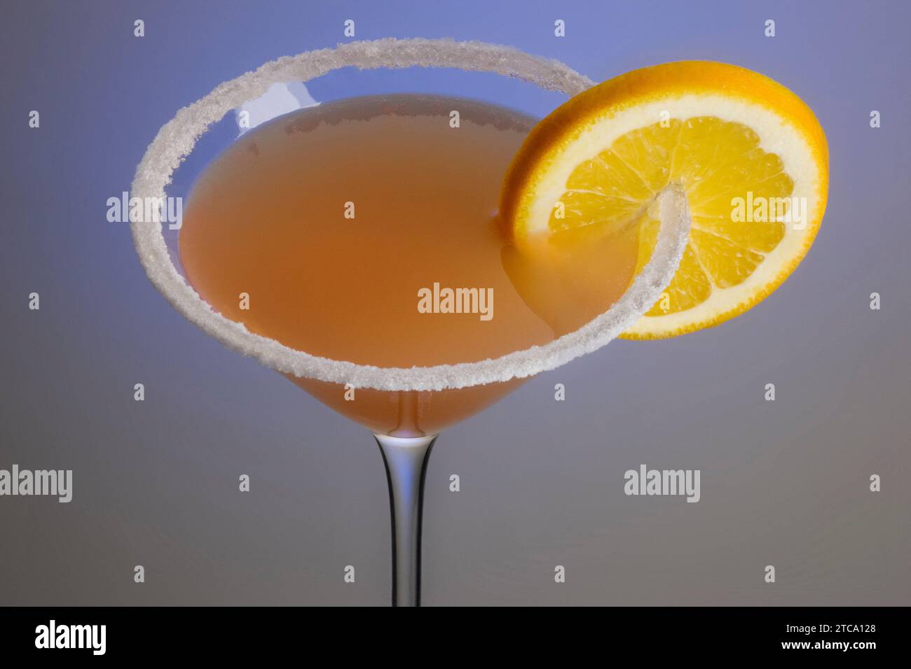 Sidecar mixed drink with orange garnish and sugar rim on plain ...