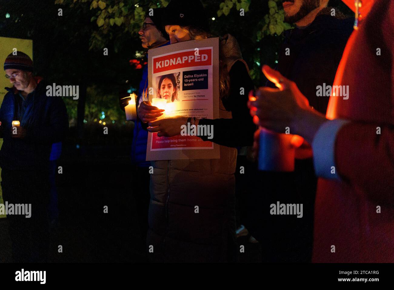 A woman holding a poster with the words kidnapped written on it, People ...