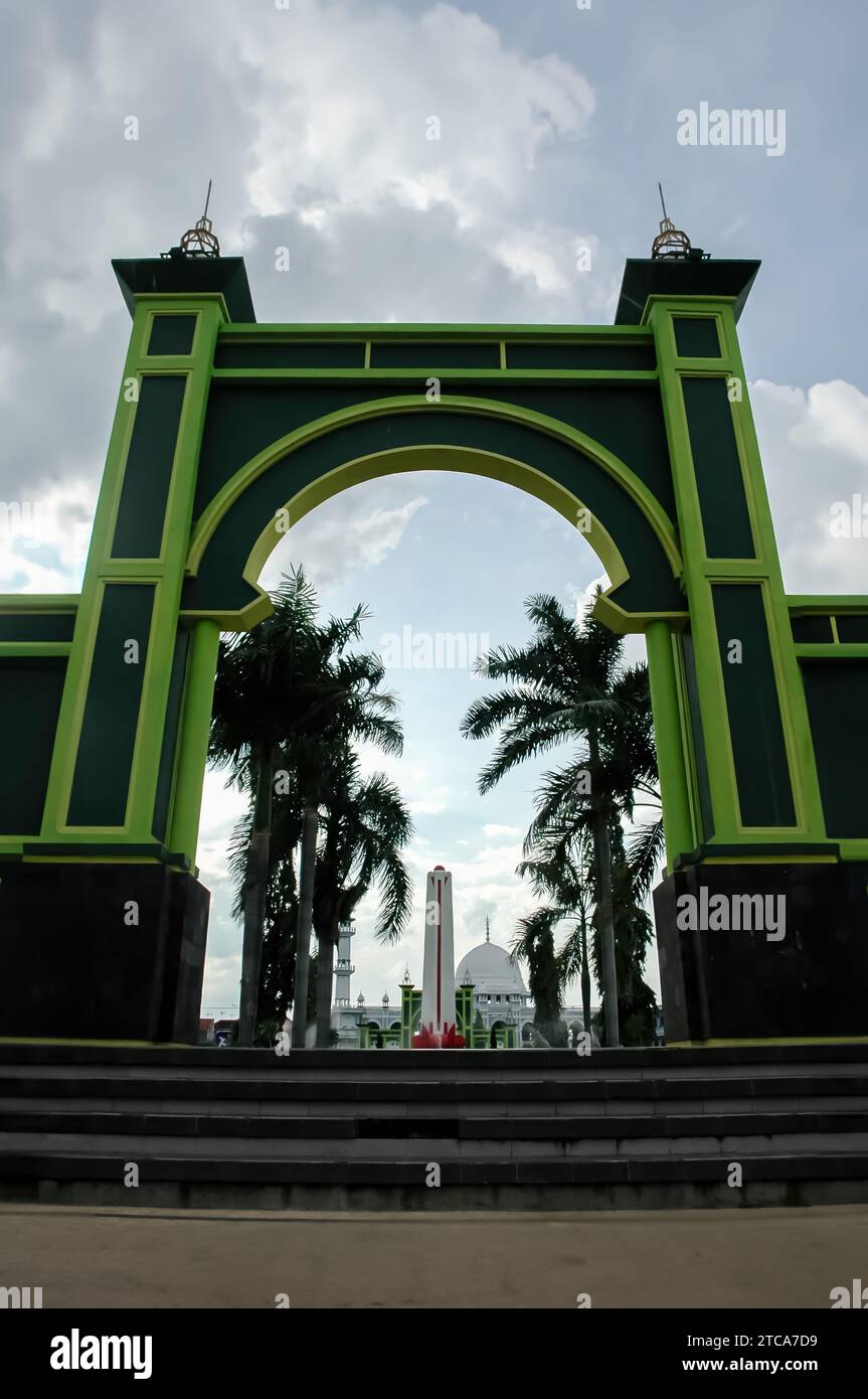The green entrance gate with a palm tree background in the city square ...