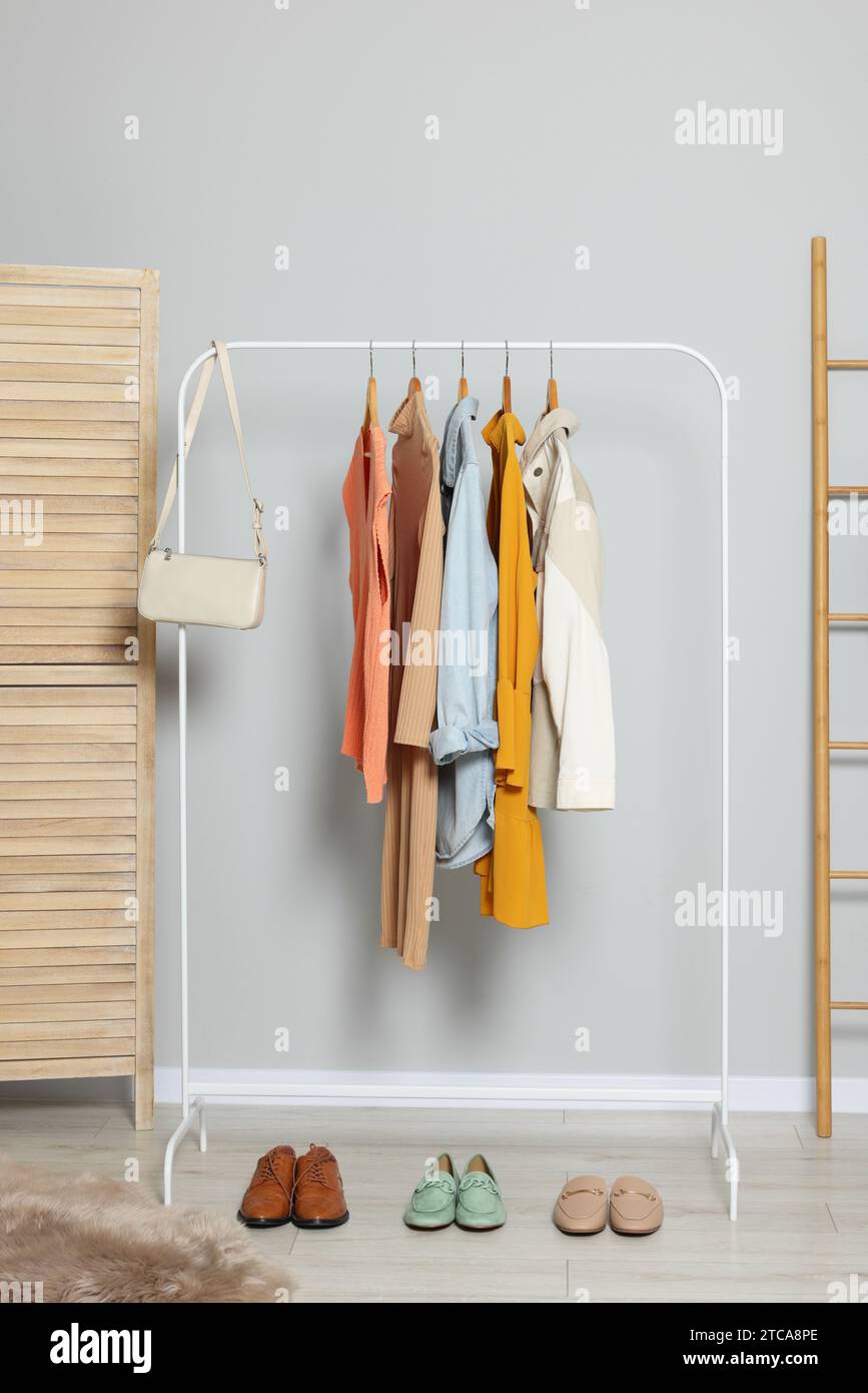 Stylish room interior with clothes rack and folding screen Stock Photo ...