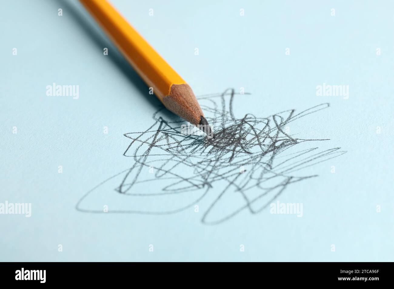 One sharp graphite pencil and scribbles on light blue background ...