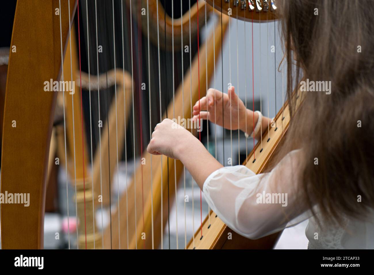Girl playing the harp hi-res stock photography and images - Alamy