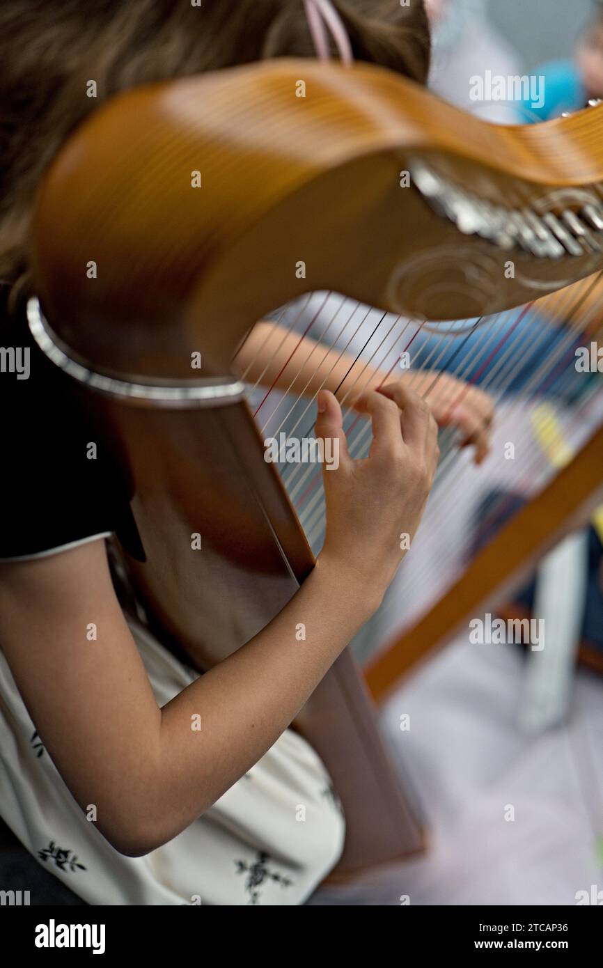 Little girl playing the harp Stock Photo - Alamy