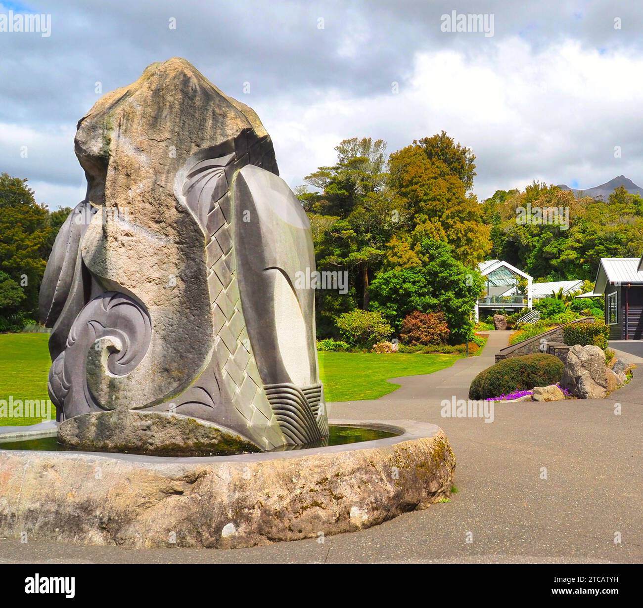 Rock sculpture with Māori motifs at the entrance to Pukeiti rainforest ...