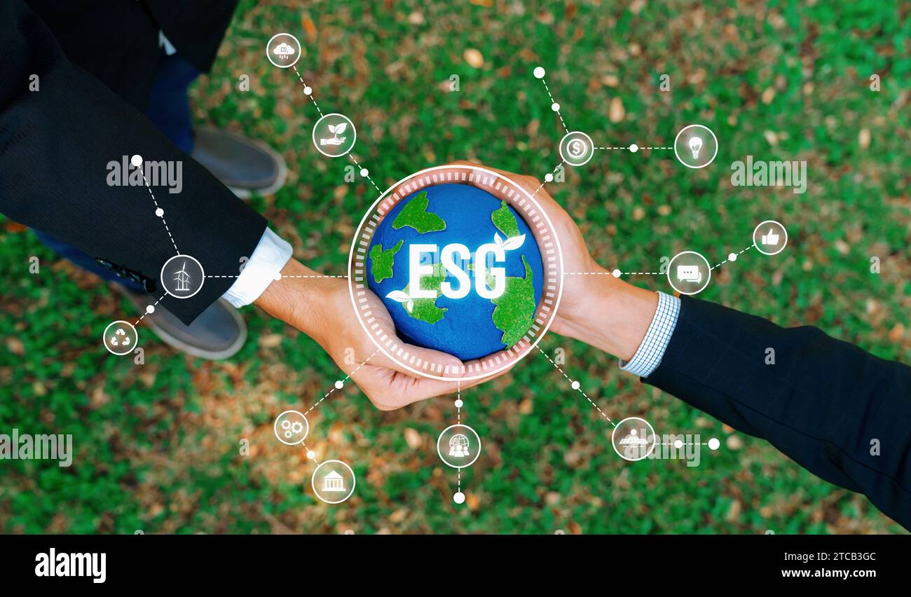 Two businessmen's hand holding planet Earth together symbolize ESG business partnership ...