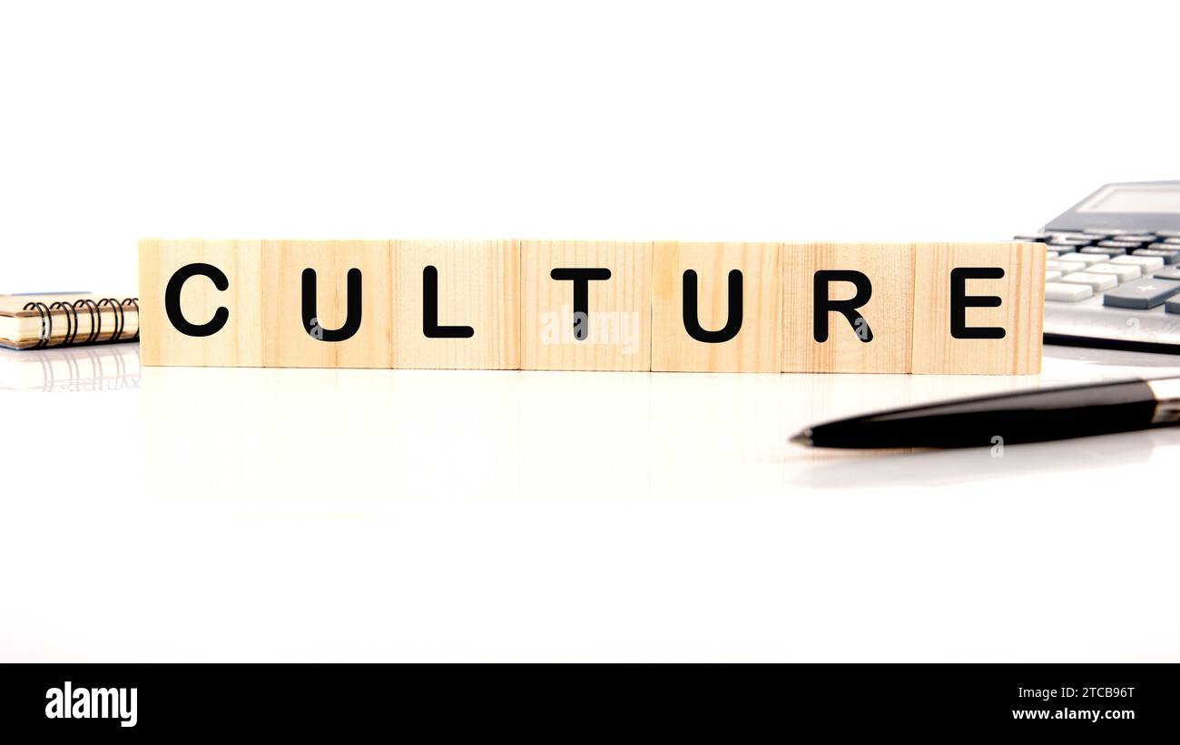 CULTURE word assembled from wooden cubes next to a calculator, pen and ...